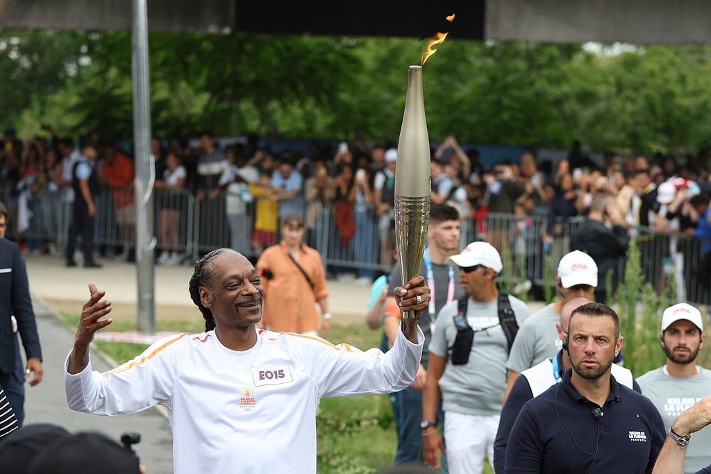 Snoop Dogg carries the Olympic torch before the opening ceremony in Paris