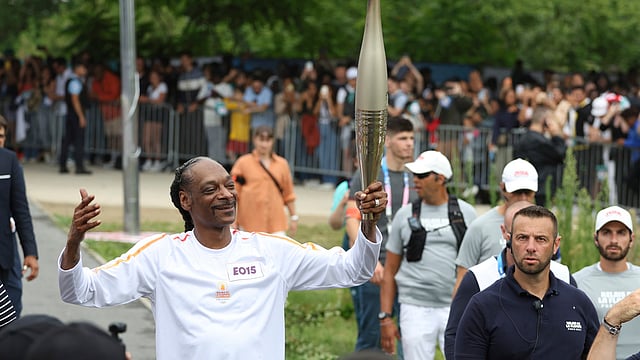 Snoop Dogg carries the Olympic torch before the opening ceremony in Paris